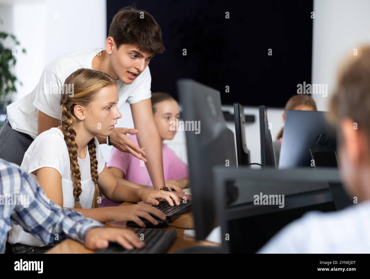Guy teacher teaches girl student how to use computer Stock Photo - Alamy