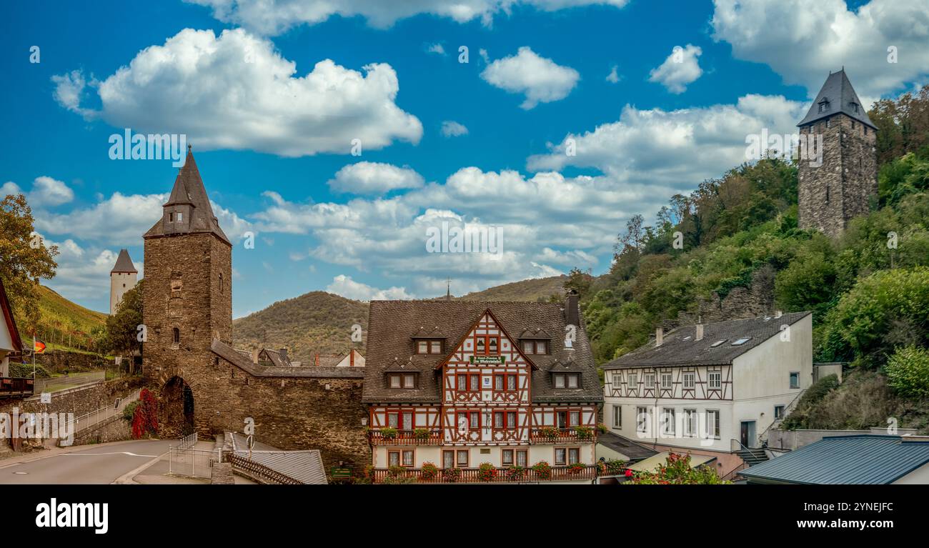 Restored medieval city gate and city walls, half timbered houses in the ...