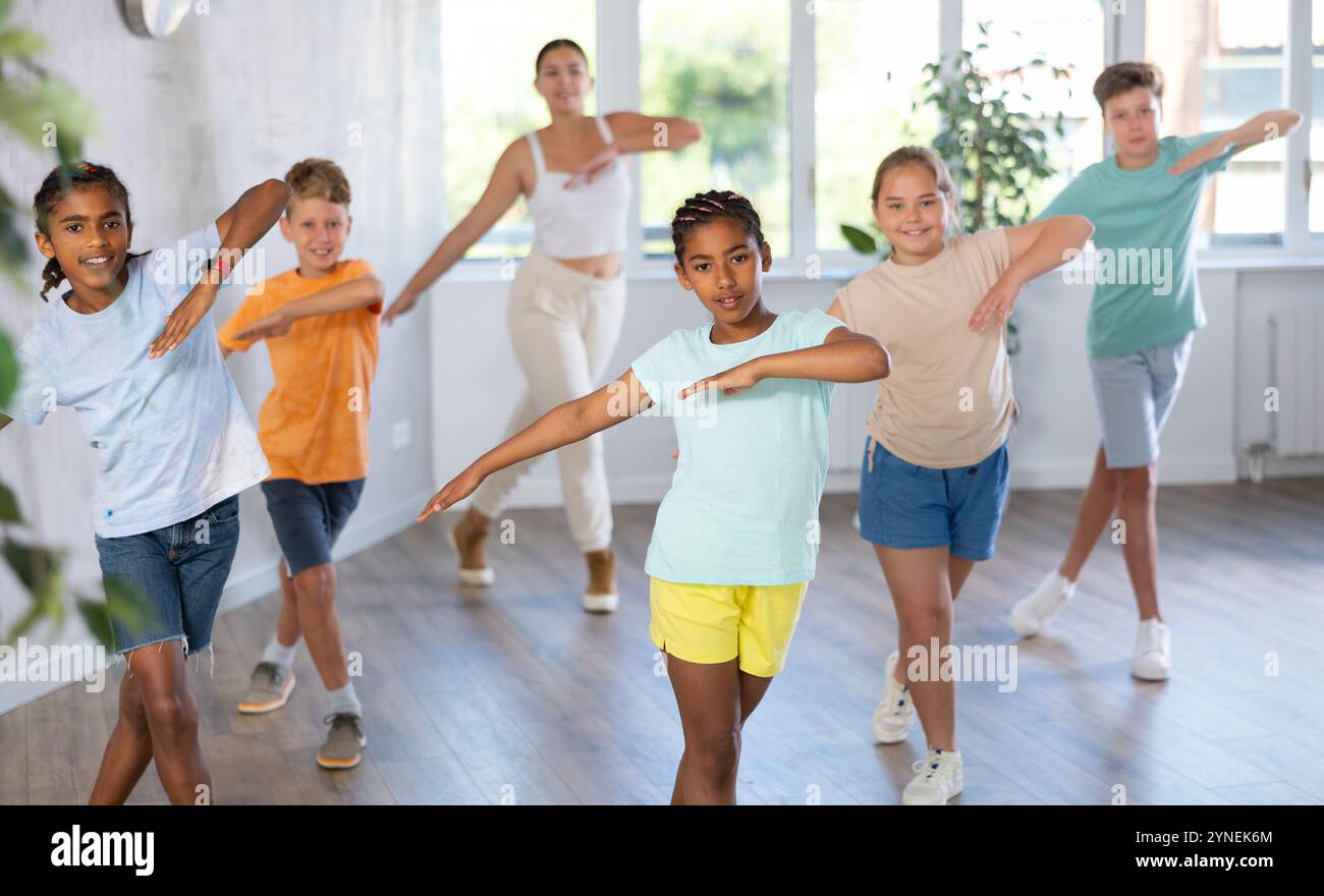 Smiling african american tween girl learning dynamic dances in ...