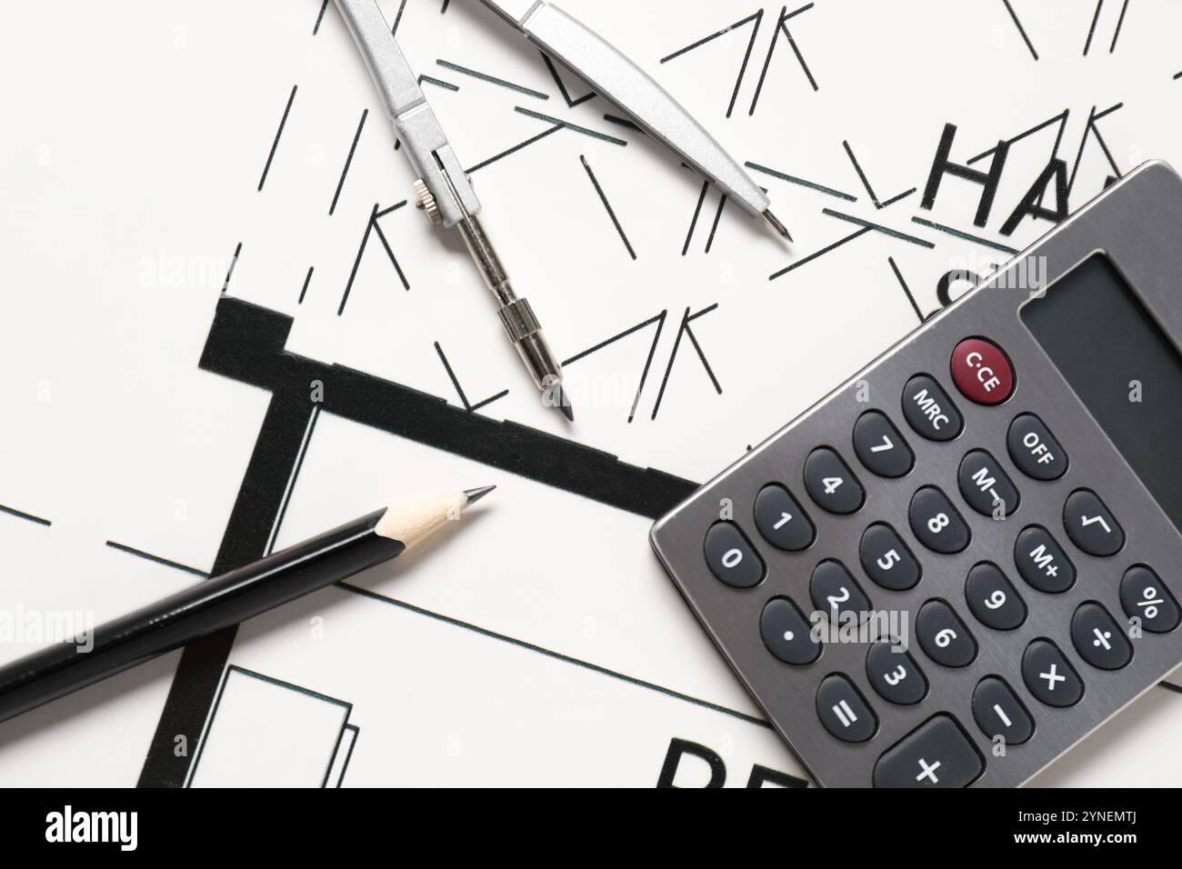 Calculator, pencil and dividers on different architectural drawings ...