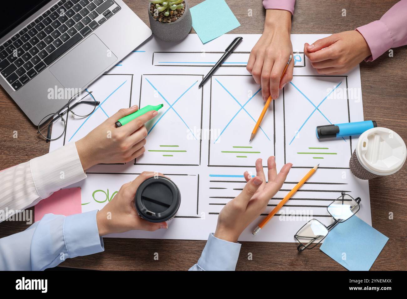 Developing UI design. Designers creating website wireframe on paper at ...