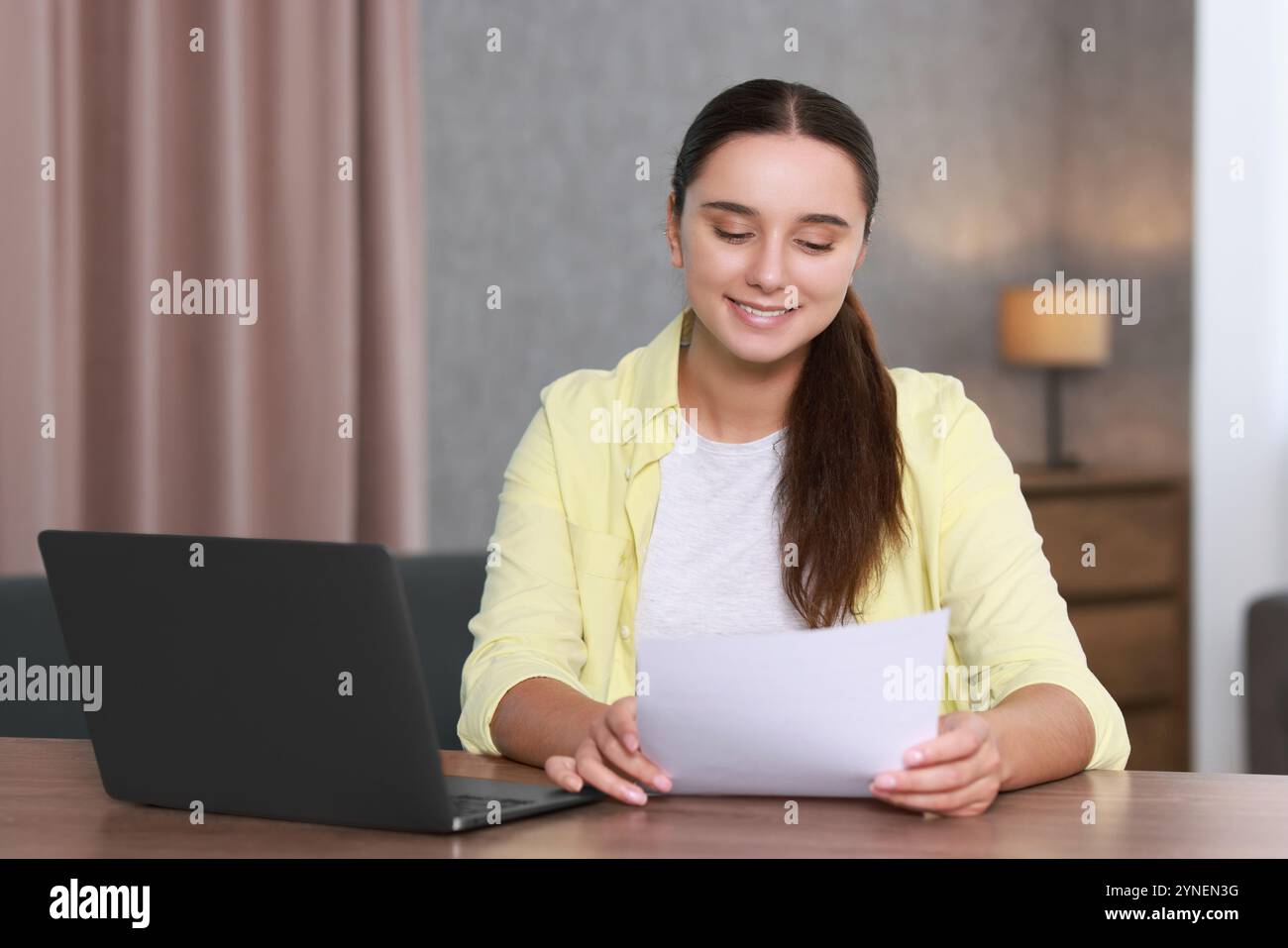 Young student with sheet happy about her good exam result at workplace ...