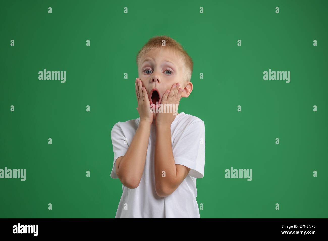 Portrait of scared little boy on green background Stock Photo - Alamy