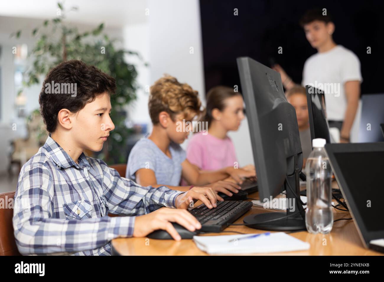 Boy student learning to work on computer in classroom Stock Photo - Alamy