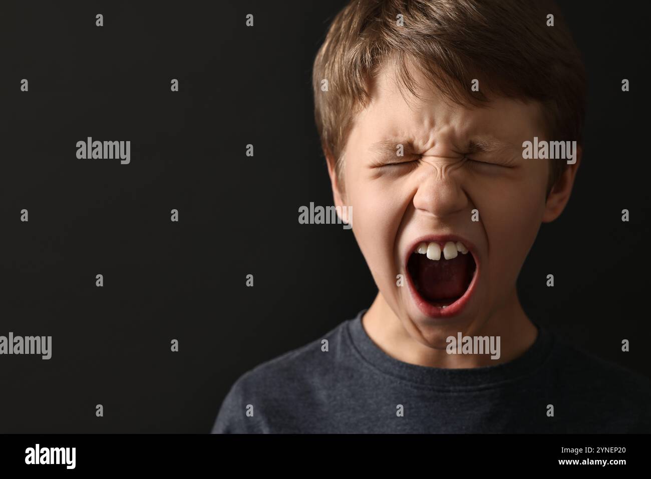 Scared little boy screaming on black background. Space for text Stock ...