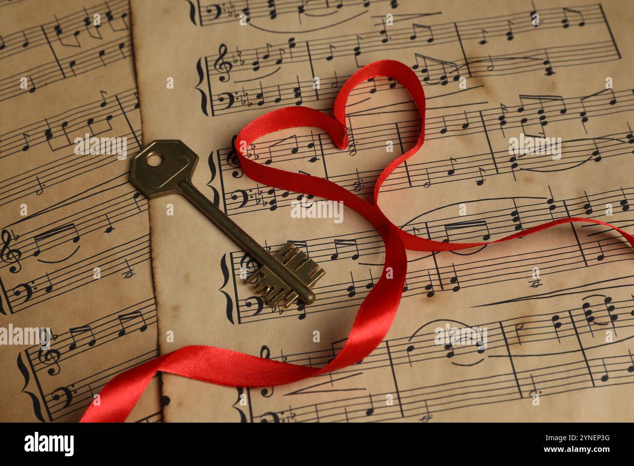 Key and heart shaped ribbon on musical notes, closeup Stock Photo - Alamy