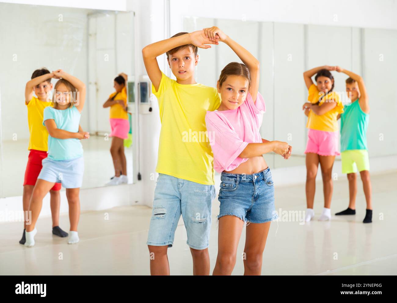 Tween boy and girl practicing slow pair dancing during group class ...