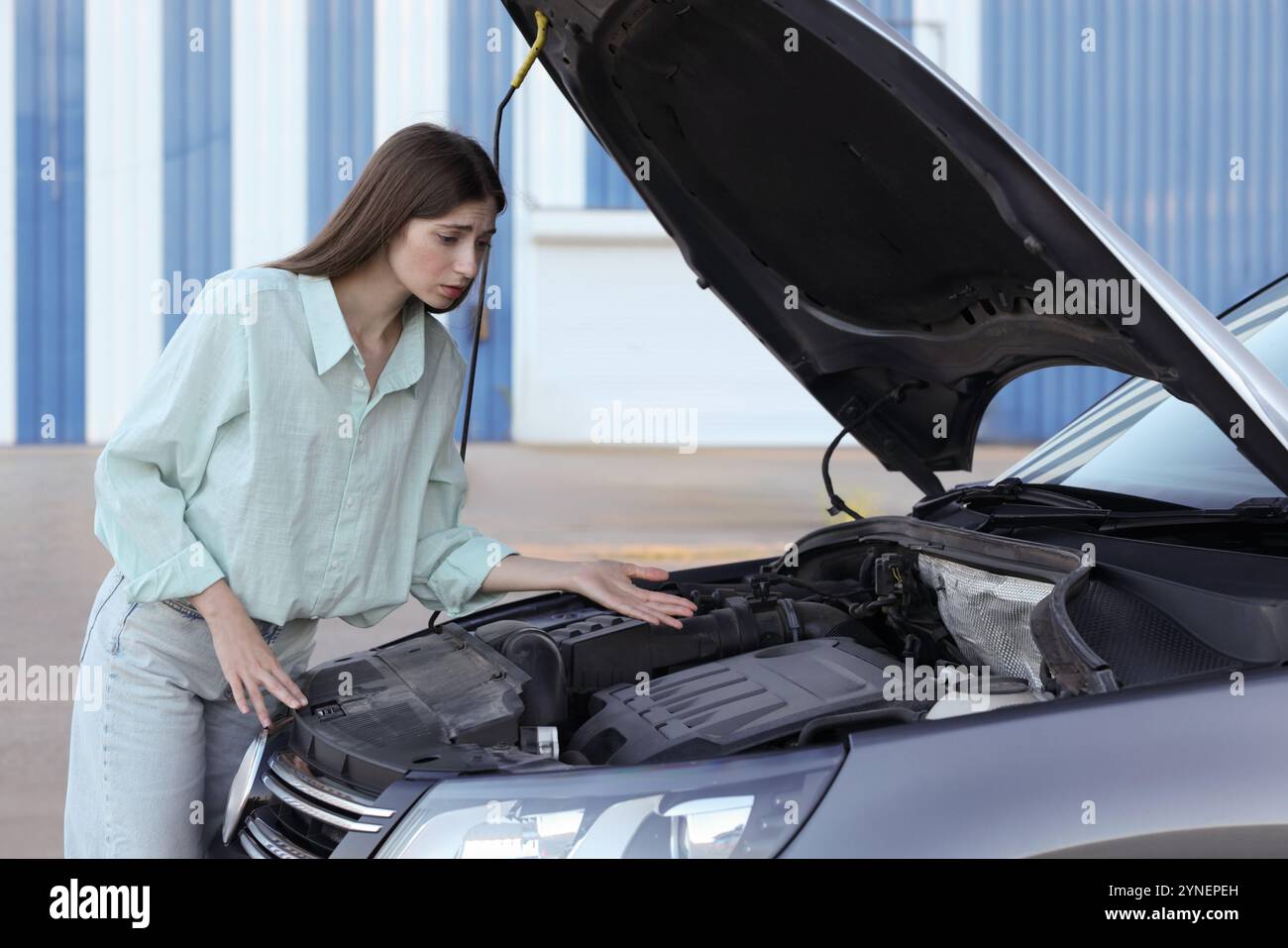 Woman looking under hood car hi-res stock photography and images - Alamy