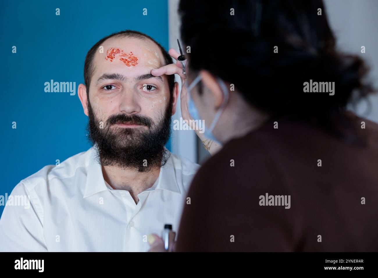 Girlfriend helping man prepare for halloween festivity, dressing him as ...