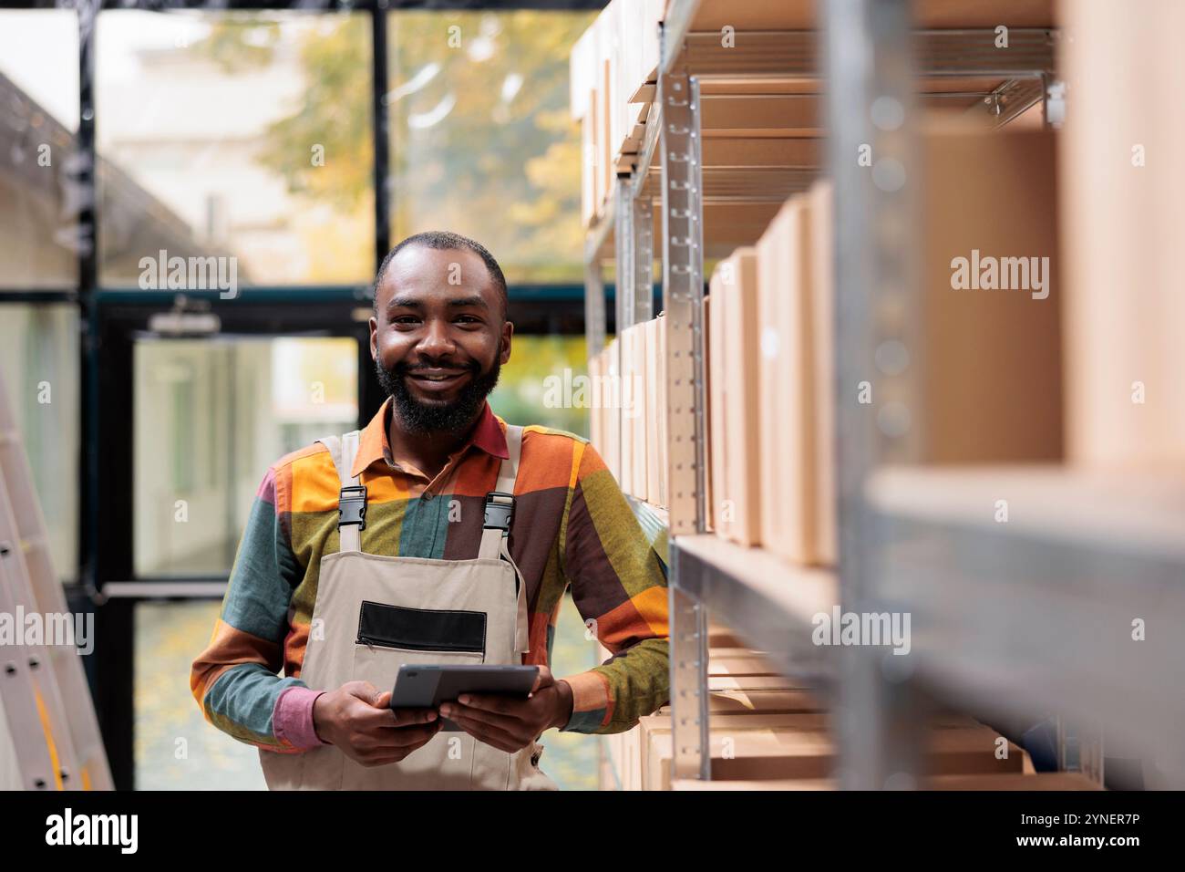 Portrait of smiling employee working storage room, preparing customers ...