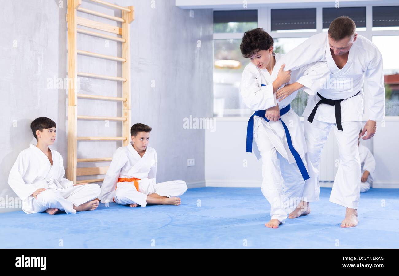 Karate sensei demonstrating fighting techniques to disciples during ...