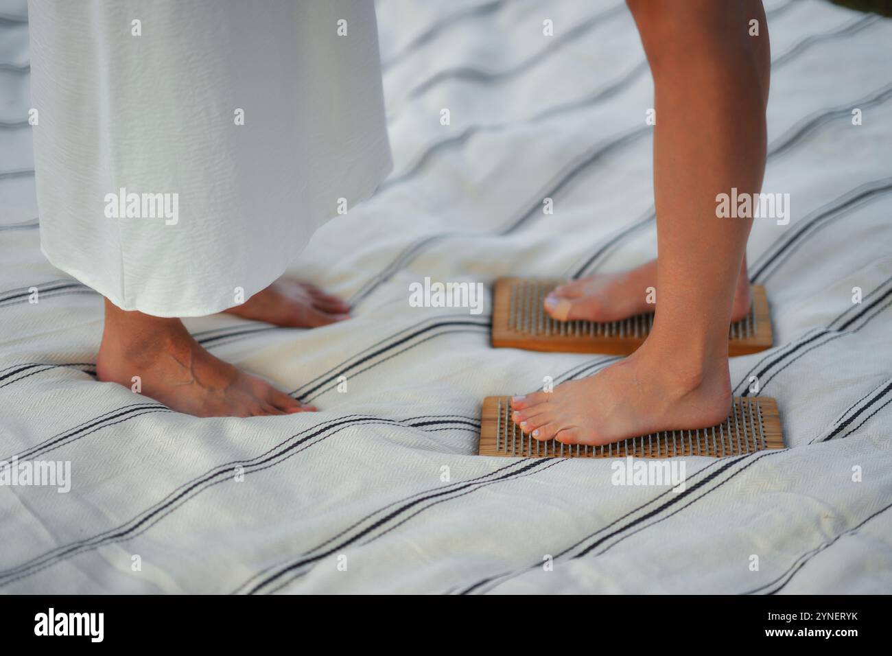 Two people using textured mats for foot therapy outdoors Stock Photo ...