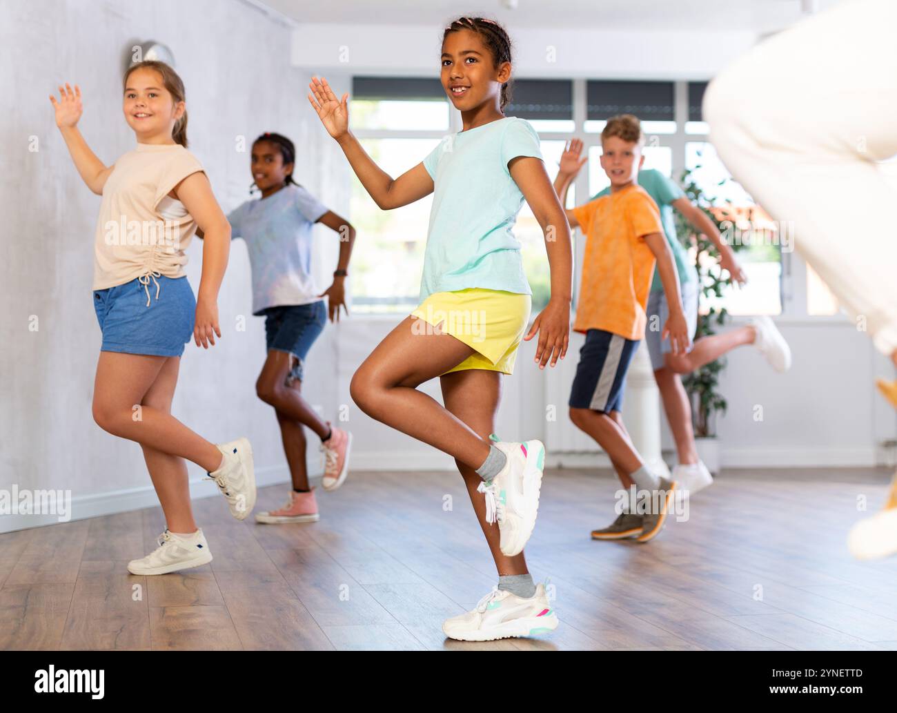 Smiling african american tween girl learning dynamic dances in ...