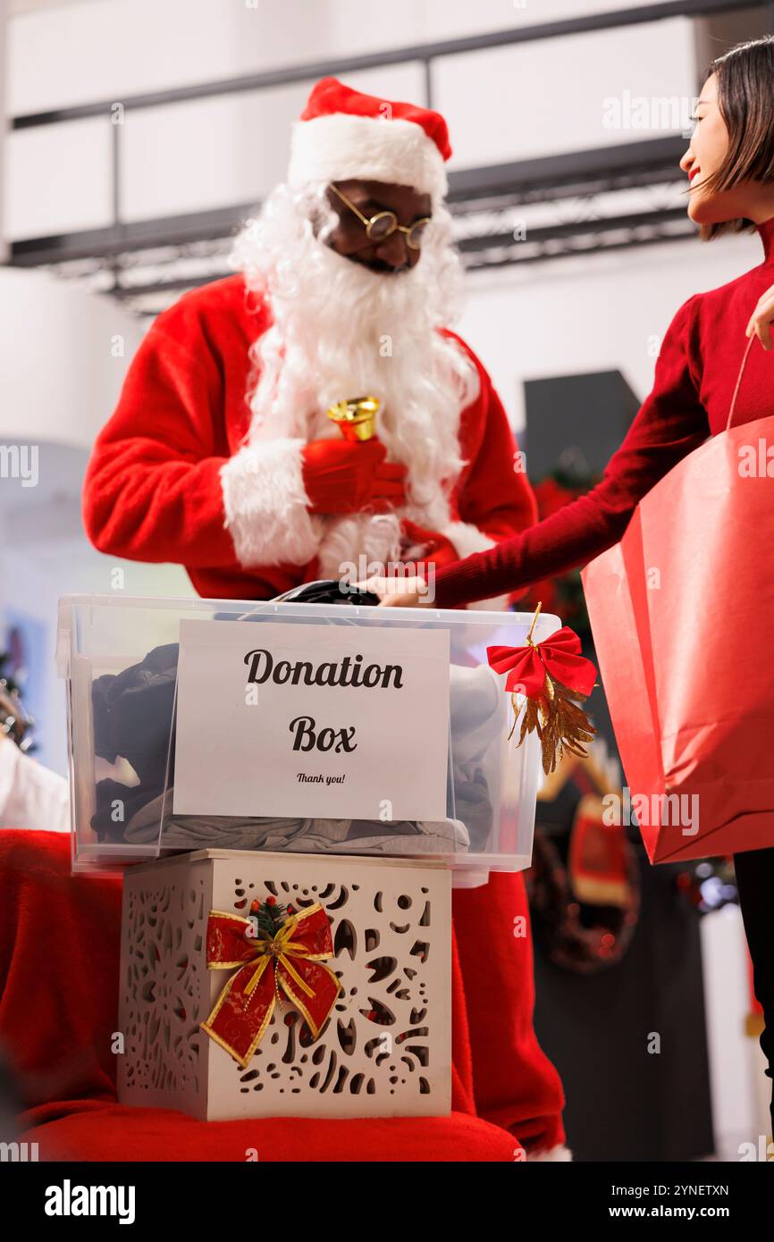 Santa Claus loading donation box with goods and apparel delivered to ...