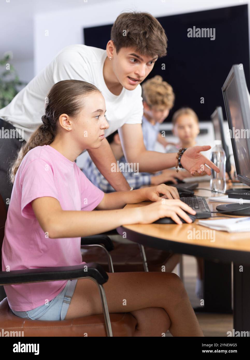 Guy teacher teaches girl student how to use computer Stock Photo - Alamy
