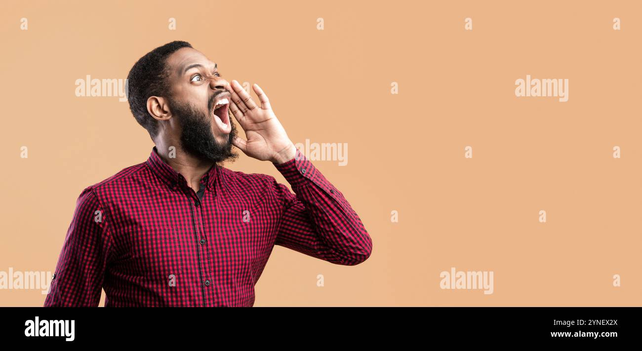 Black guy holding hand near mouth, screaming aside at copyspace Stock ...