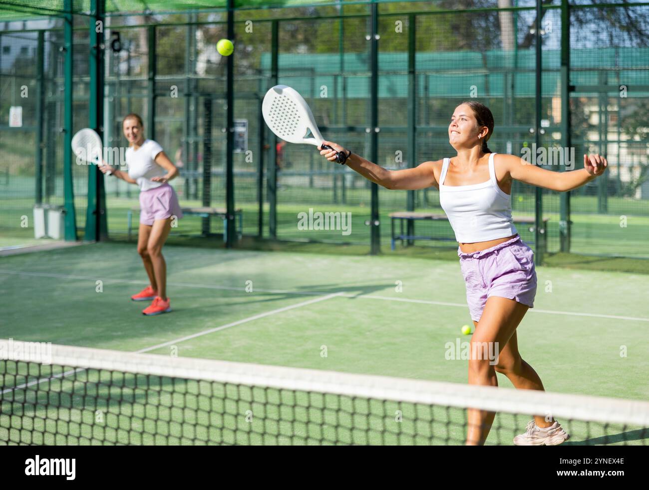 Padel game - woman with partners plays on tennis court Stock Photo - Alamy