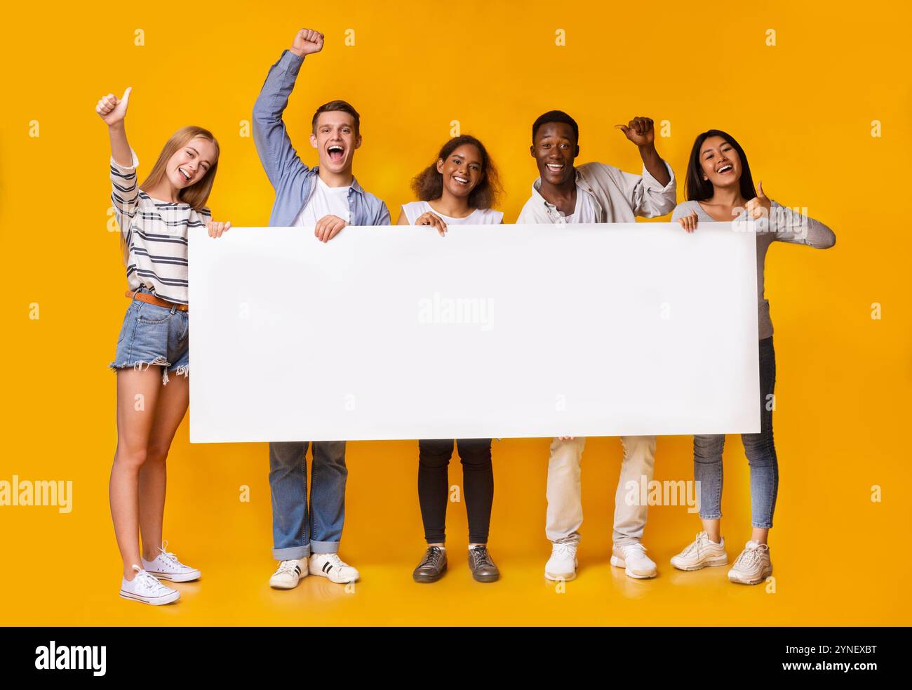 Happy smiling group of students standing together with white placard ...