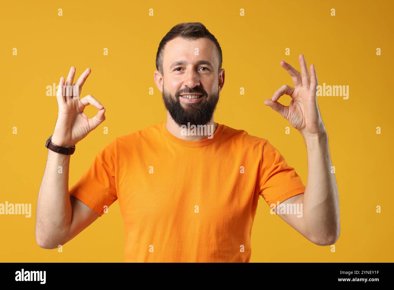 Man showing okay gesture on orange background Stock Photo - Alamy
