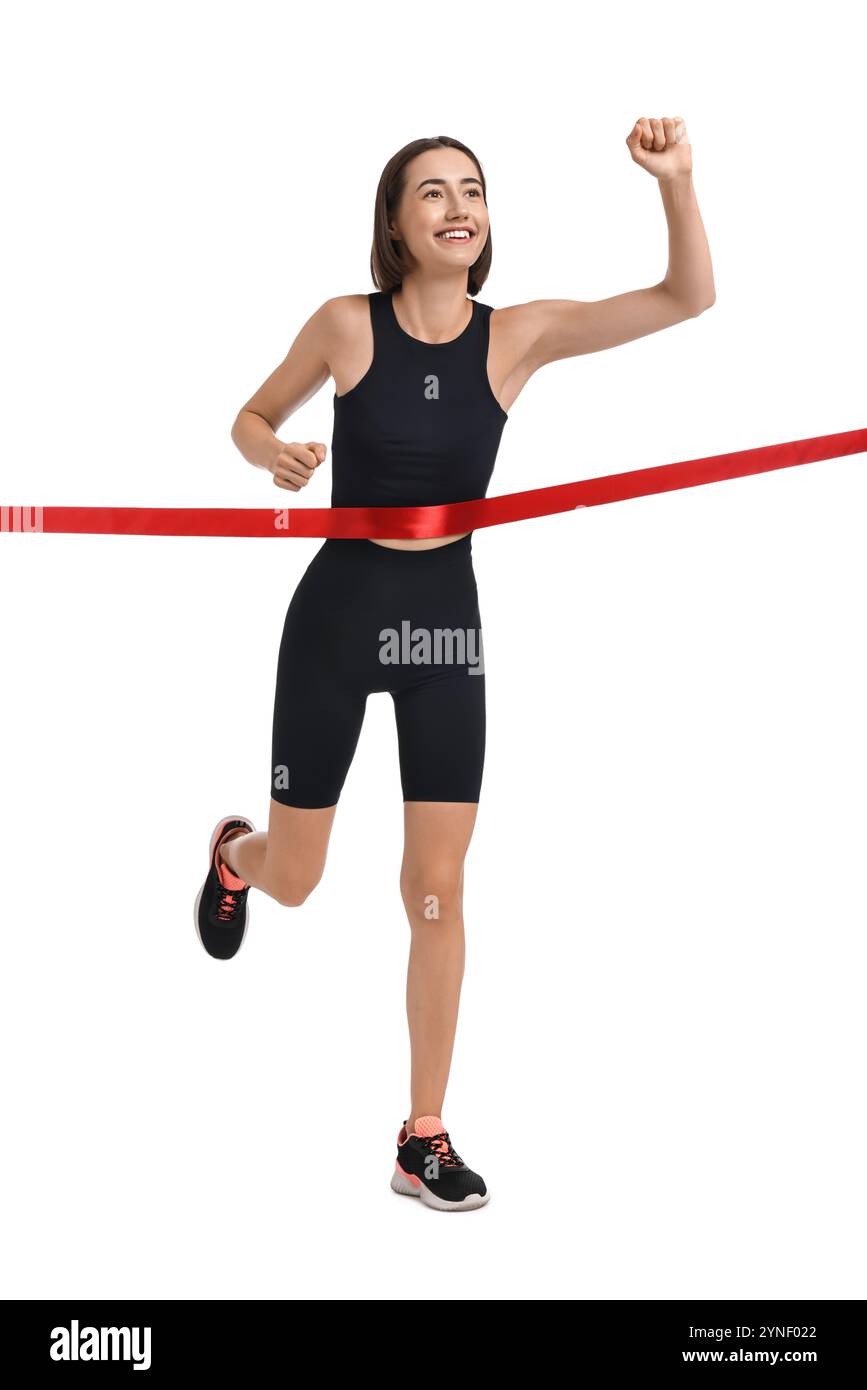 Beautiful woman in sportswear crossing red finish line on white ...