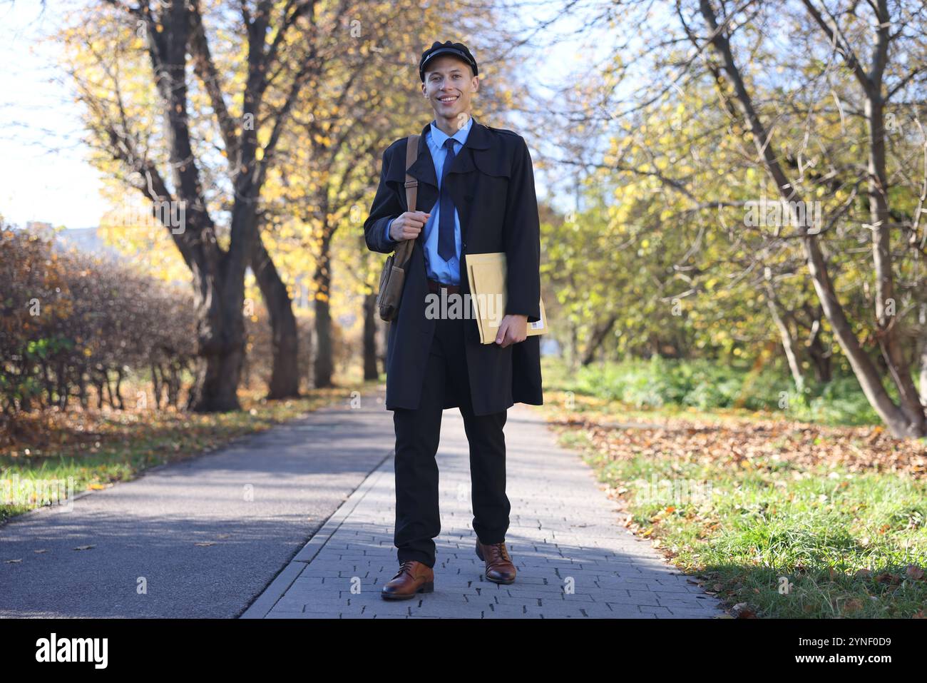 Happy postman with bag and envelopes outdoors Stock Photo - Alamy