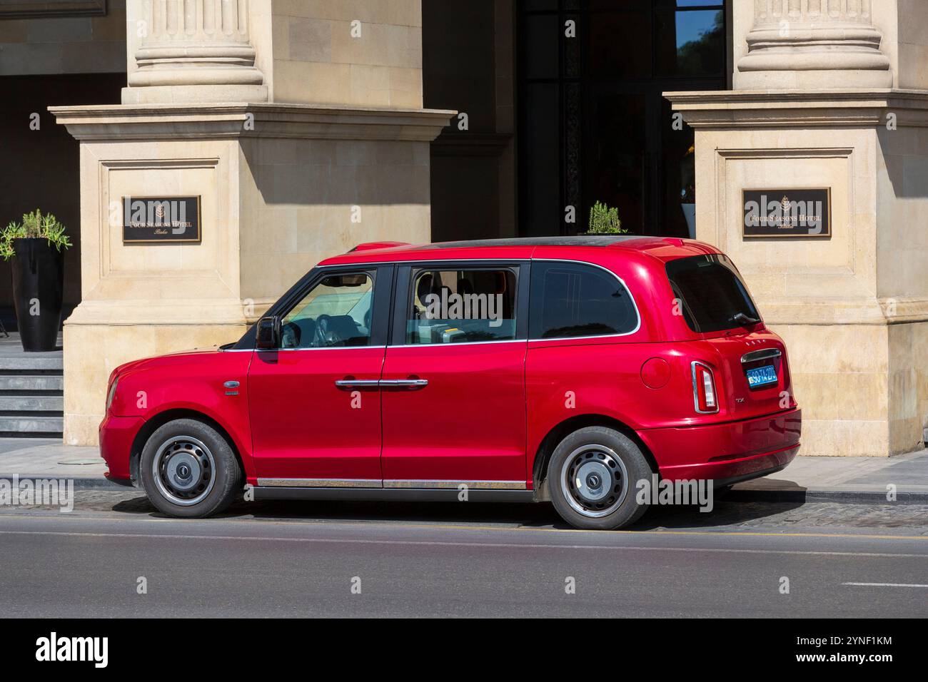 A red taxi waiting at the main entrance of the 5-star Four Seasons ...