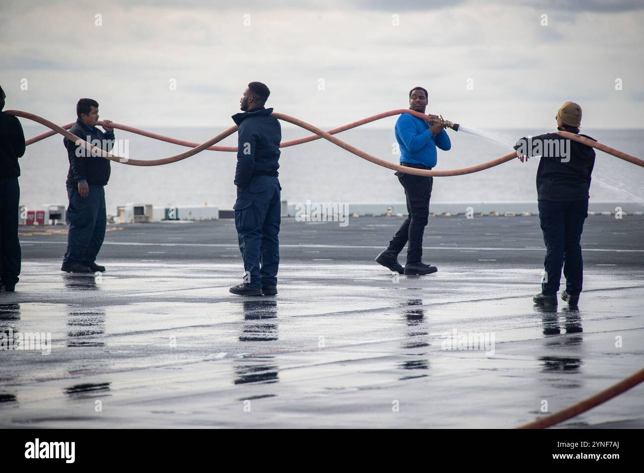 241124-N-XP477-1313 Sailors carry firefighting hoses on the flight deck ...