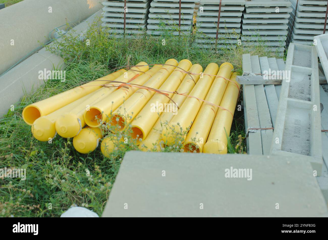 Wide view skid of Prestressed Cement Planks and plastic yellow pipe In ...