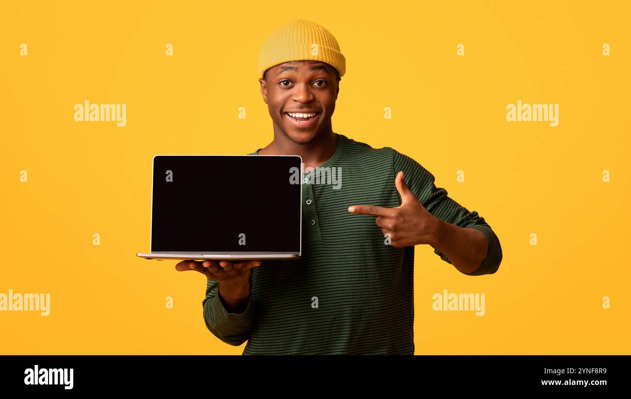 Cool Website. Cheerful African Guy Pointing At Laptop Computer With ...