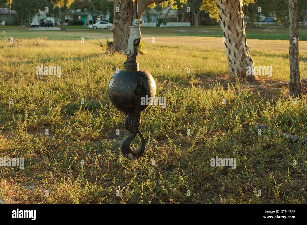 An isolated black crane ball hook hanging from cable attached to a ...