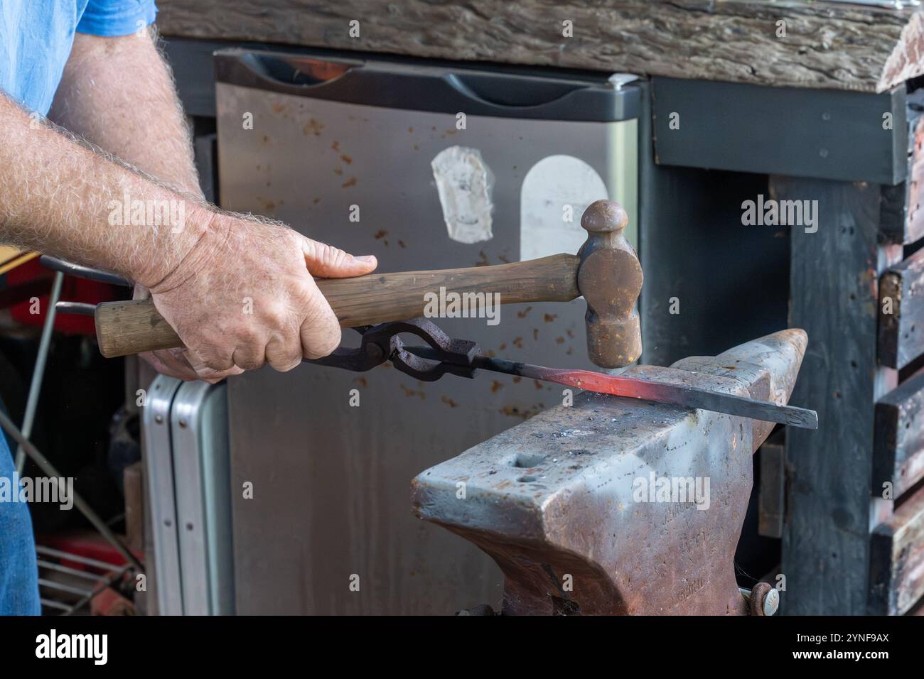 Blacksmith forging horseshoe hammering glowing metal steel on anvil ...