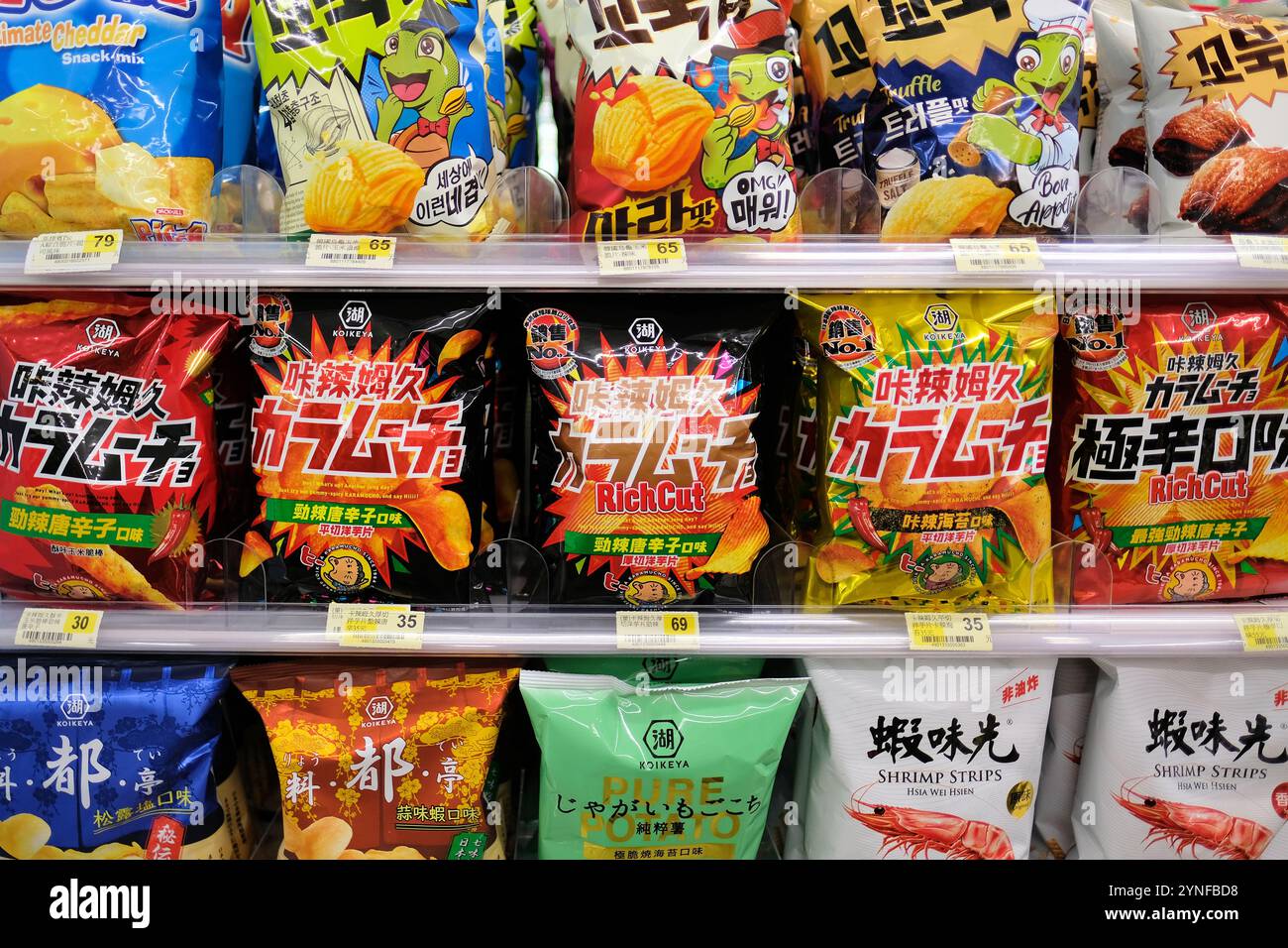 Assorted potato chip bags and brands in local flavors on a display rack ...