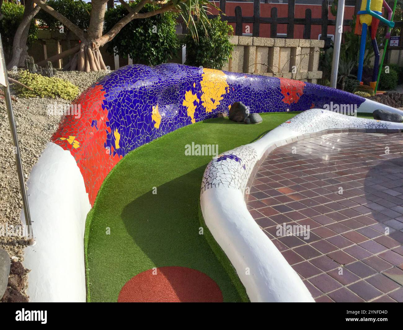 A vibrant mosaic wall features bright colors set in a landscaped ...