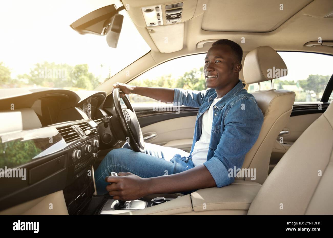 Happy black guy driving car, inside shot Stock Photo - Alamy