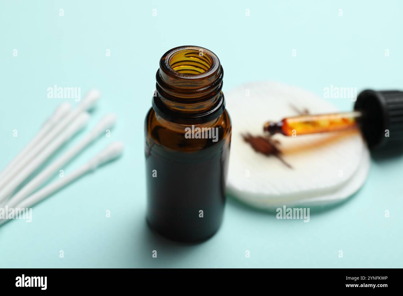 Bottle of topical iodine, cotton pads and swabs on light blue ...