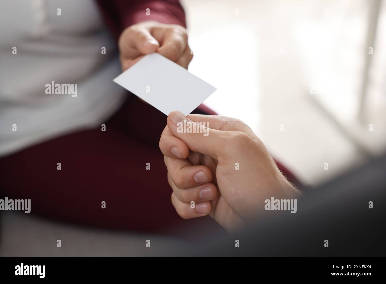 Woman giving business card to man in office, closeup. Mockup for design ...
