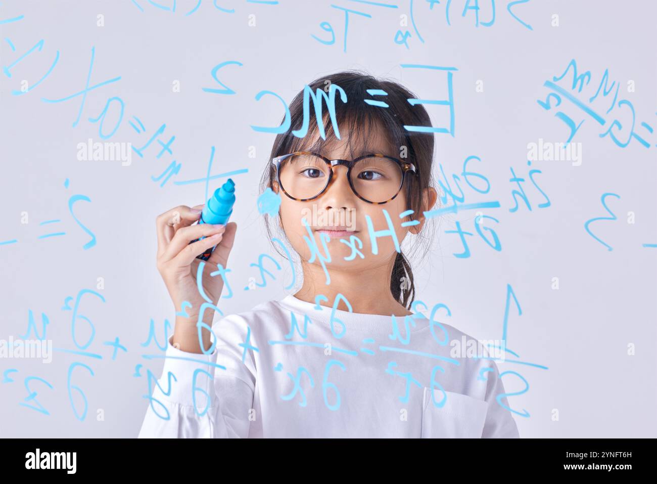 Japanese girl in glasses writing on a white board with math formulas ...