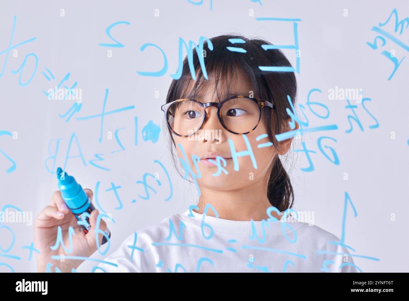 Japanese girl wearing glasses writing on a white board with math ...
