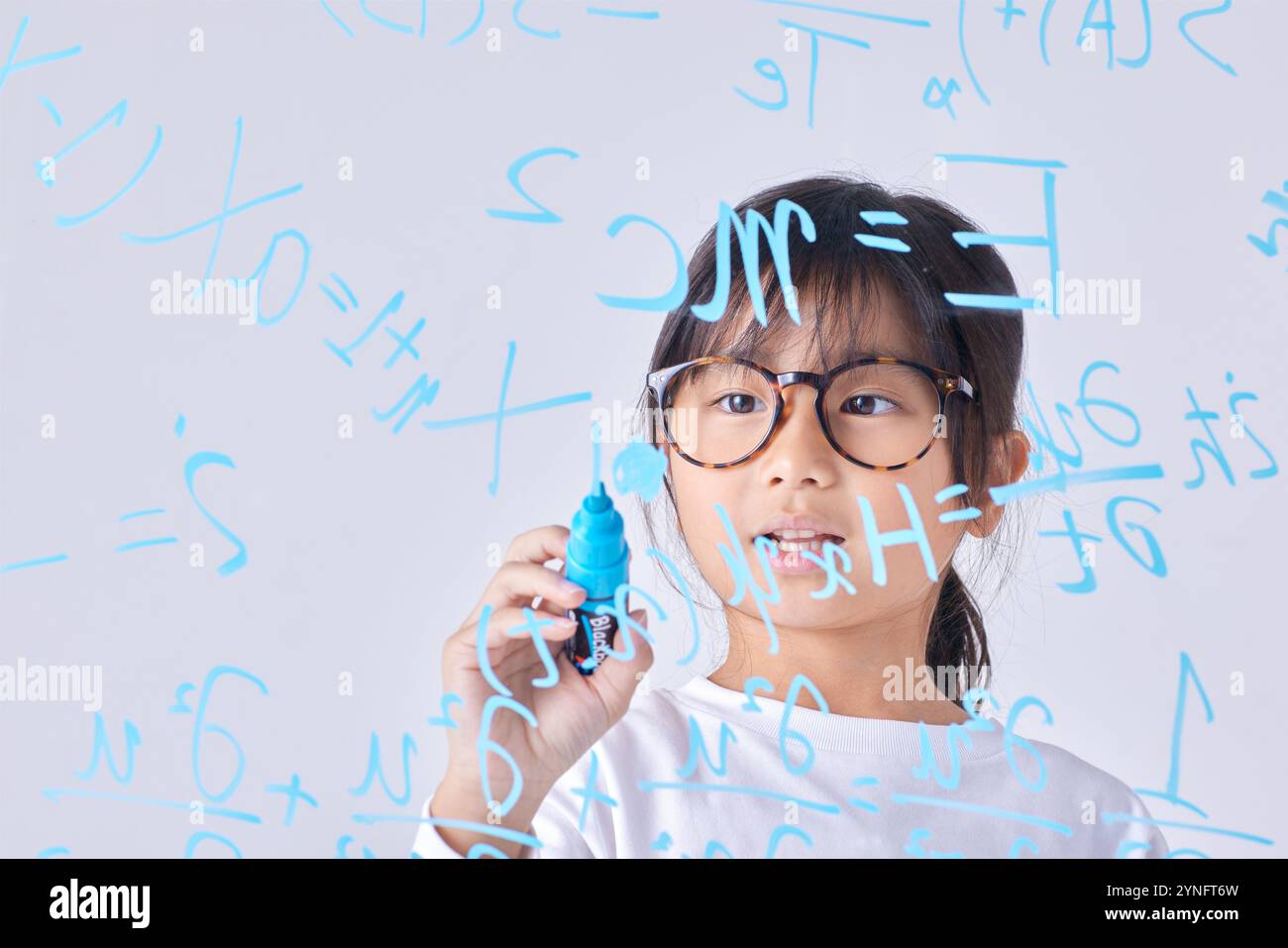 Japanese girl in glasses writing on a white board with math formulas ...