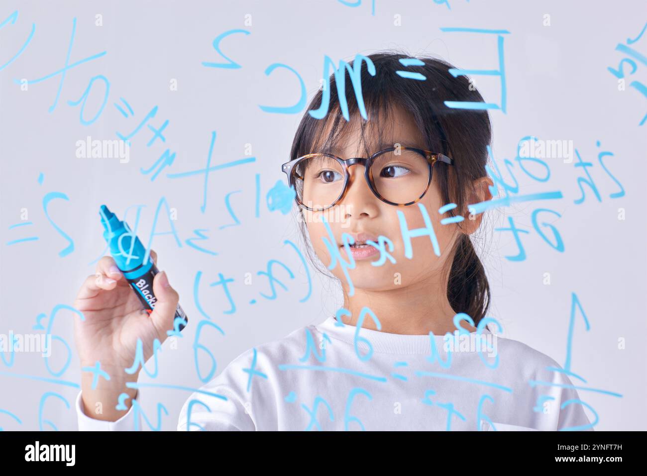 Japanese girl in glasses writing on a white board with math formulas ...