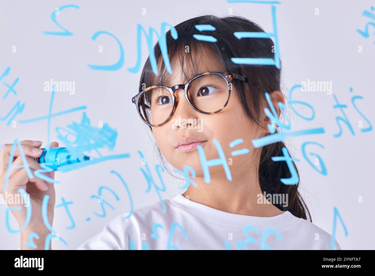 Japanese girl wearing glasses writing on a white board with math ...