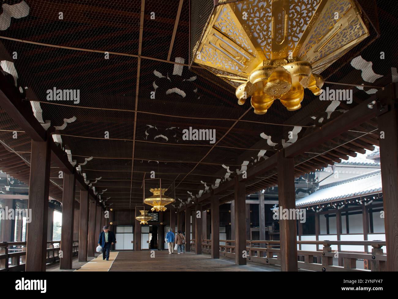 Golden lanterns hanging from the roof rafters in a long outdoor ...