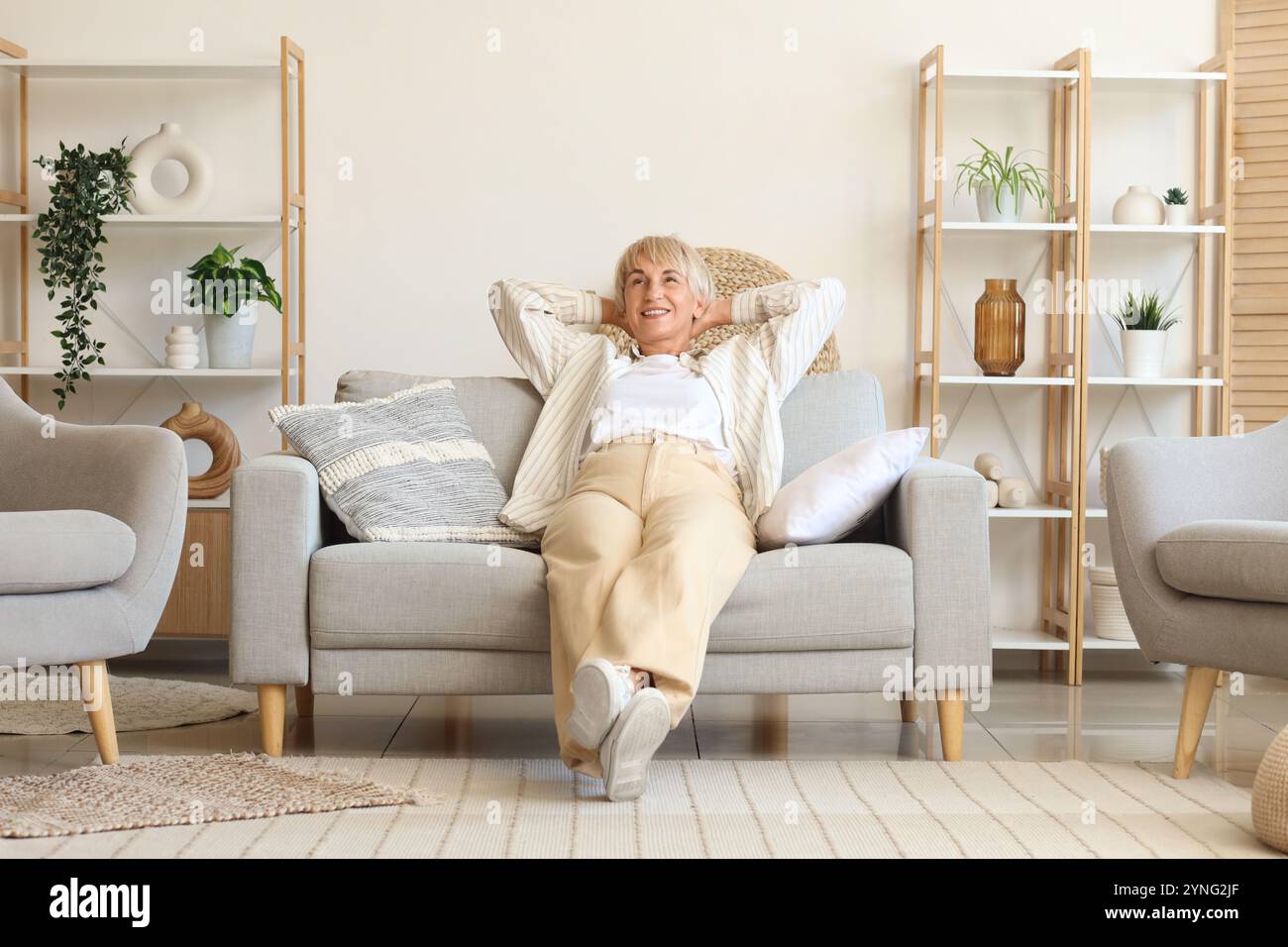 Old woman resting on sofa at home Stock Photo - Alamy