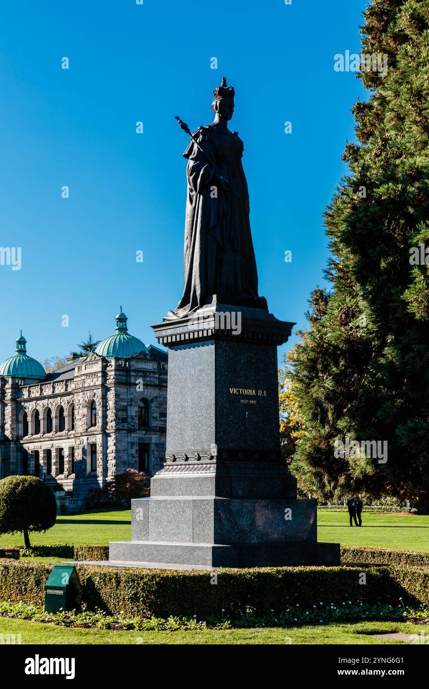 A statue of a woman stands in front of a building. The statue is of ...