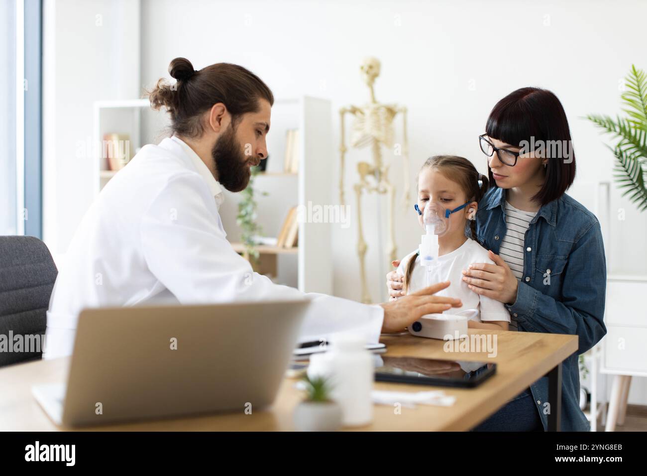 Doctor provides nebulizer treatment to young girl at medical clinic ...