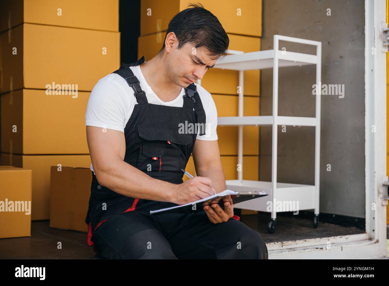 Workers in uniform unload boxes checking checklist with a clipboard at ...