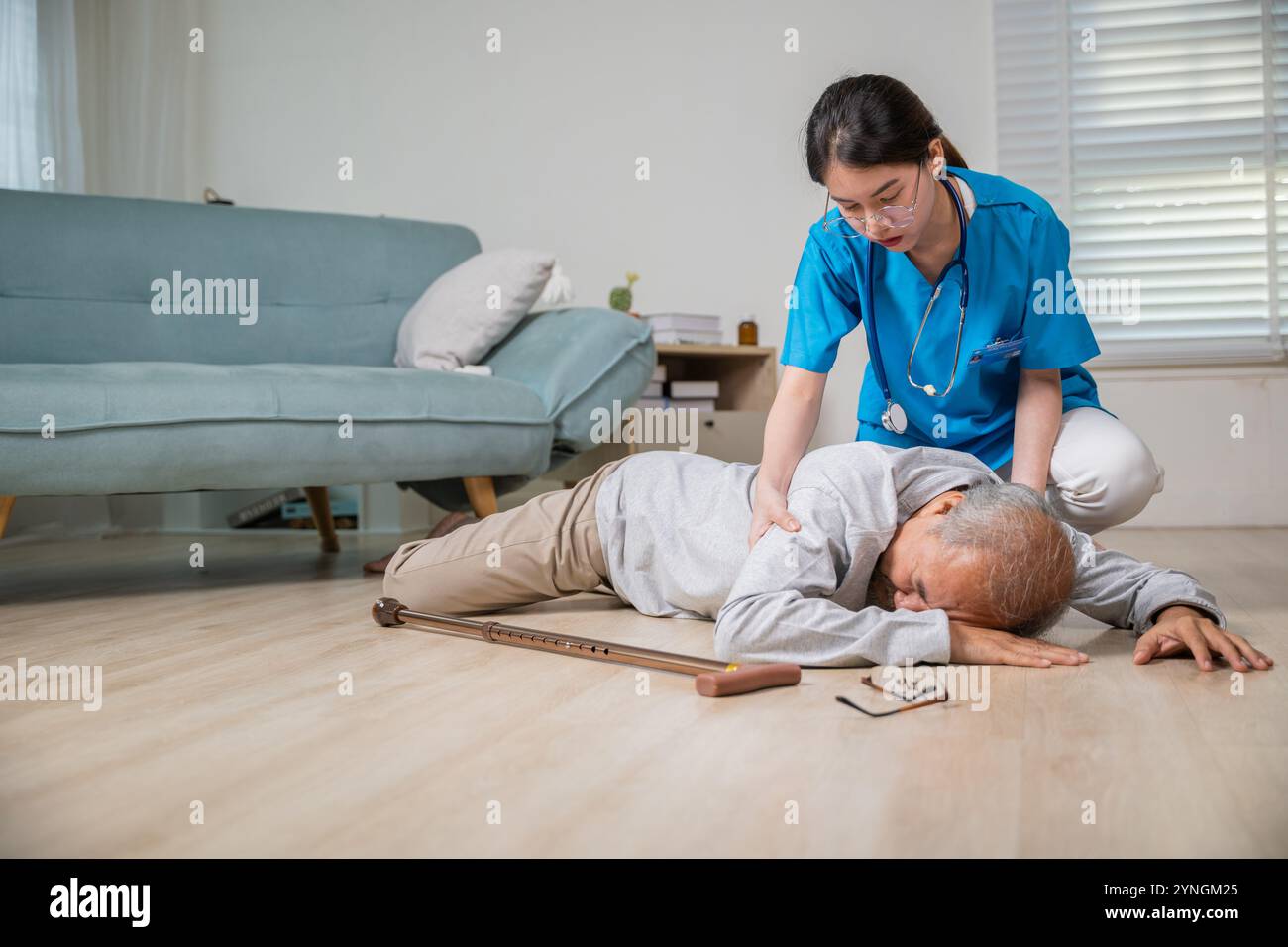 Asian older senior man falling down on lying floor and woman nurse came ...