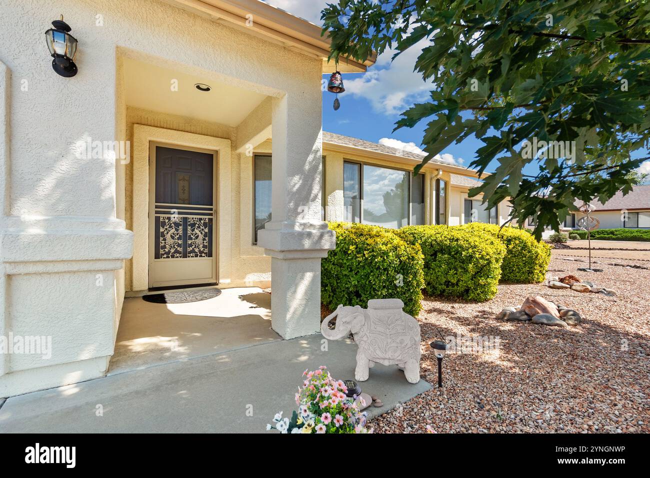 Charming entrance of a well-maintained home with lush landscaping and ...