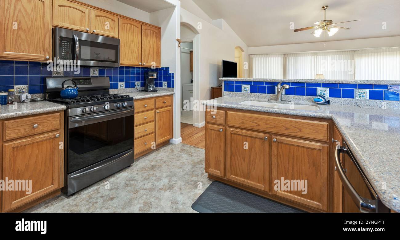 Modern kitchen with wood cabinets and bright blue tiles for freshness ...