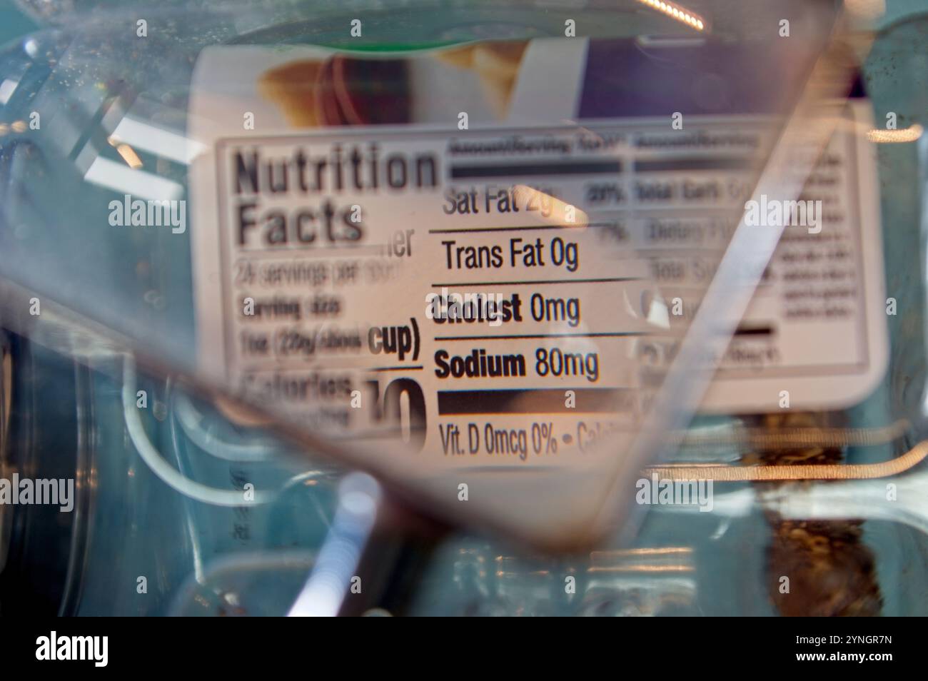 Magnifying glass focusing on cholesterol and sodium on a food label ...